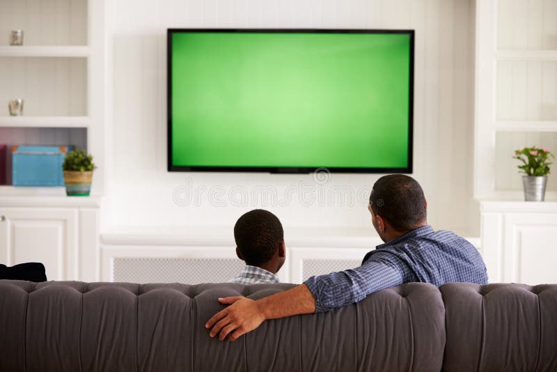 Father and Son Watching TV at Home Together, Back View Stock Image ...