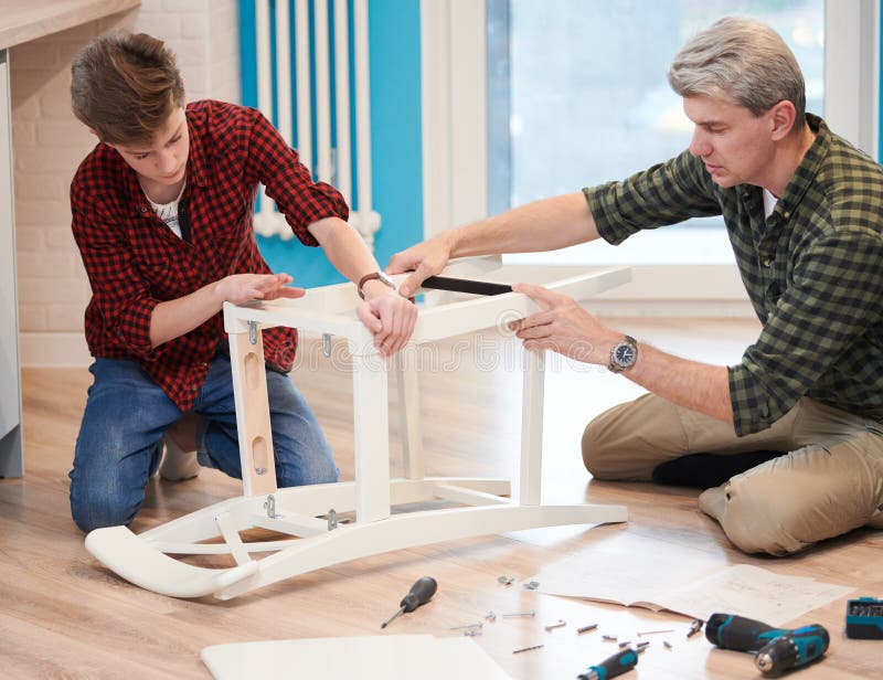 Father and Son Work Together. Kitchen Chair Assembling Stock Image ...
