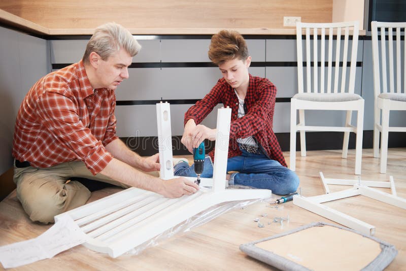 Father and Son Work Together. Kitchen Chair Assembling Stock Image ...