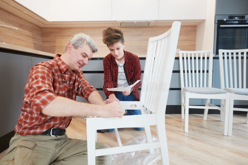 Father and Son Work Together. Kitchen Chair Assembling Stock Photo ...