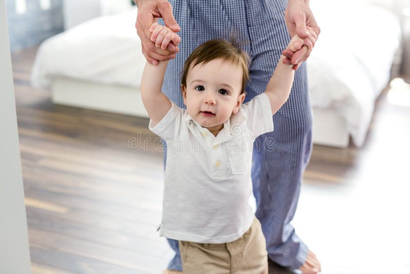 Father Teaching a Baby To Walk in the Bedroom at Home Stock Photo ...