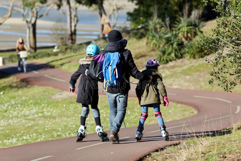 Father Teaching His Young Daughters To Rollerblade Stock Photo - Image ...