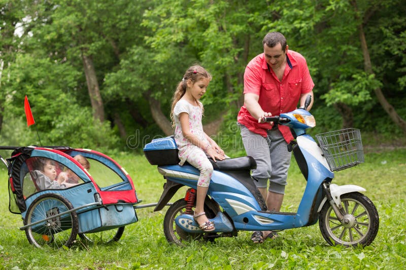 Father and Three Children on a Scooter with Cart Stock Photo - Image of ...