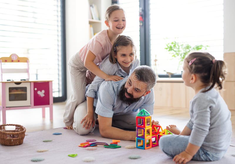 Father with Three Daughters Indoors at Home, Playing on Floor. Stock ...