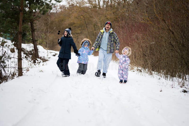 Father with Three Kids Holding Hands and Walking in Winter Forest Stock ...