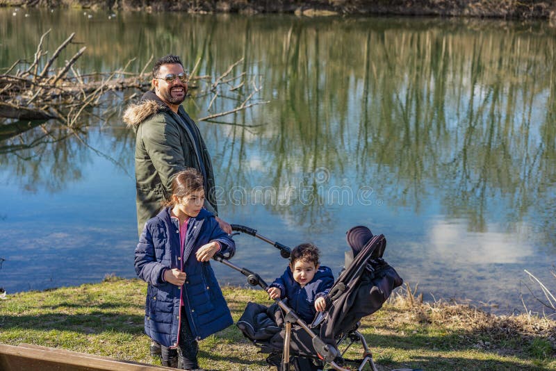 Father with Two Children is Walking Along the Aare River in Springtime ...