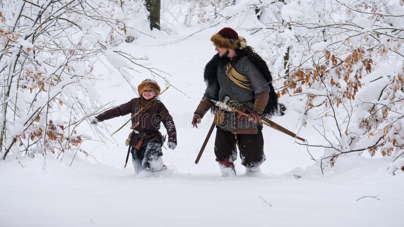 Father Viking with His Son Going in the Winter Forest. Stock Photo ...