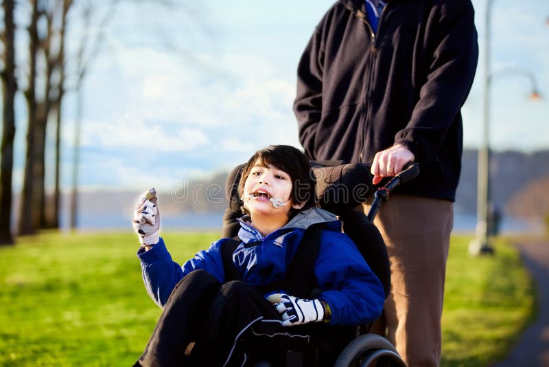 Father Walking with Disabled Son in Wheelchair Stock Photo - Image of ...