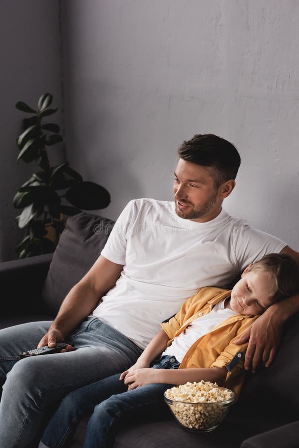 Father Watching Tv Near Son Sleeping Stock Image - Image of family ...