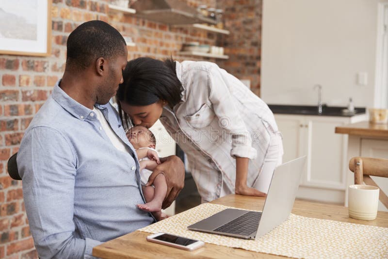 Father Working on Laptop Holds Newborn Son with Mother Stock Image ...