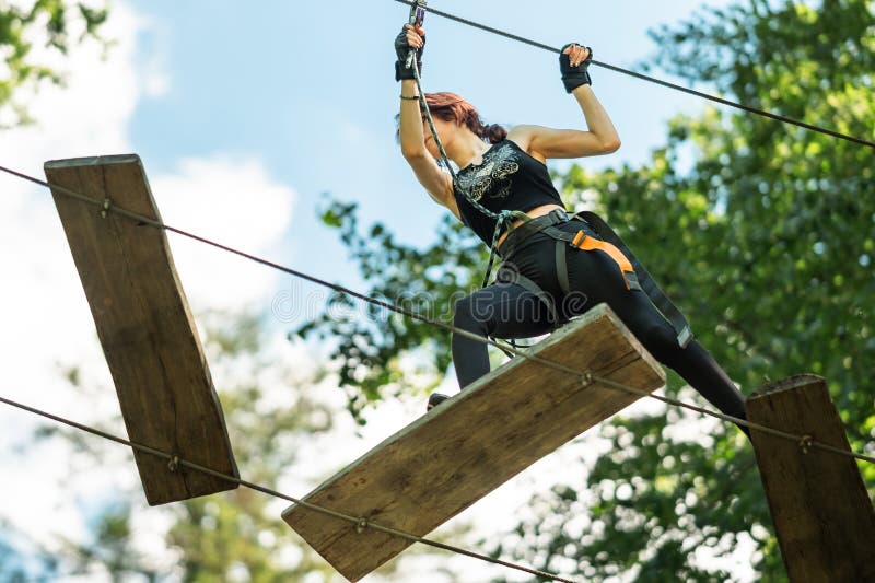A Fearless Woman Skillfully Navigating a Challenging High Rope Course ...