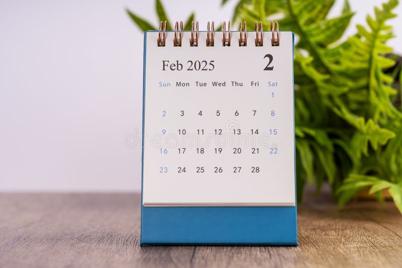 February Calendar on a Table with a Green Plant Background and a White ...