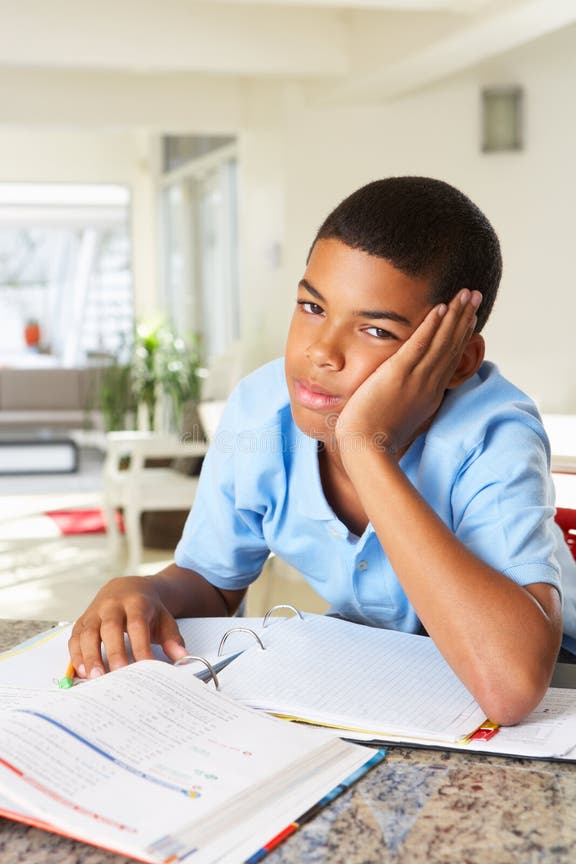 Fed Up Boy Doing Homework En Cocina Foto de archivo - Imagen de infeliz ...