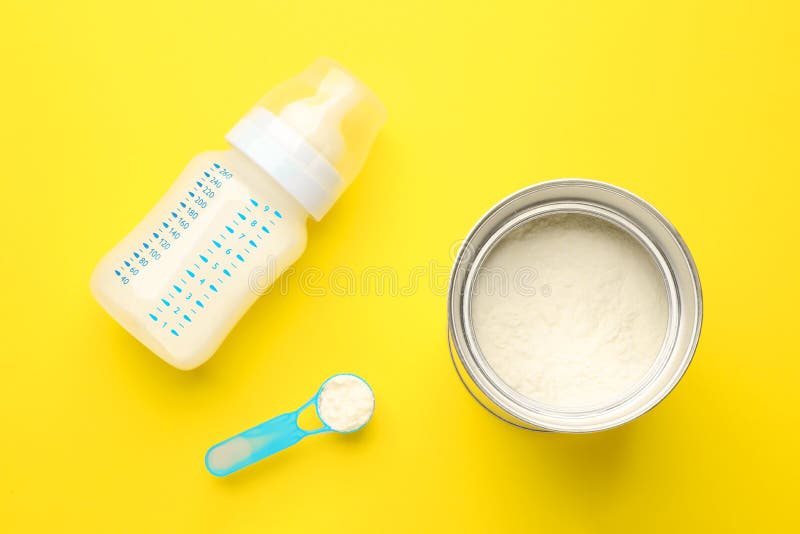 Feeding Bottle with Infant Formula and Powder on Yellow Background ...