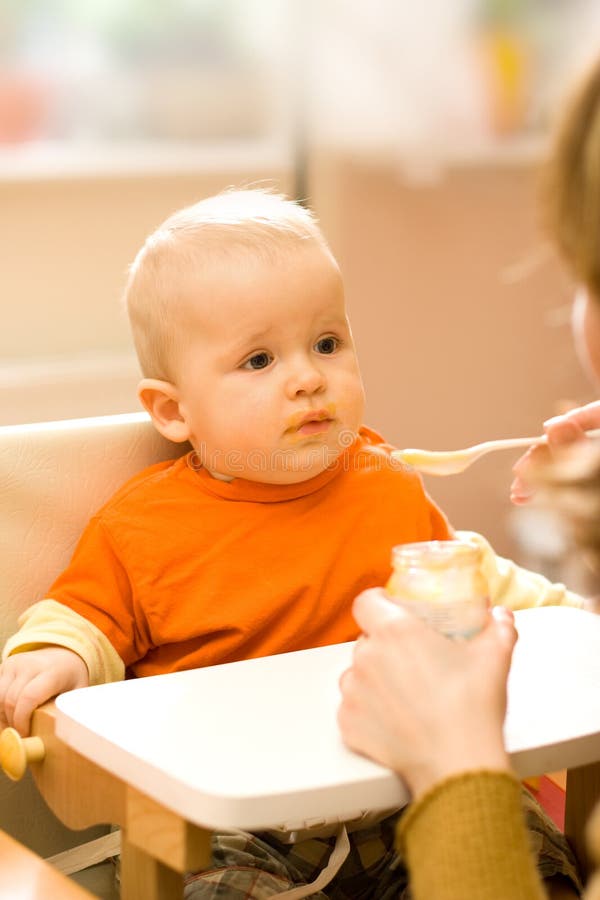 Feeding a little baby boy stock image. Image of colorful - 5589837