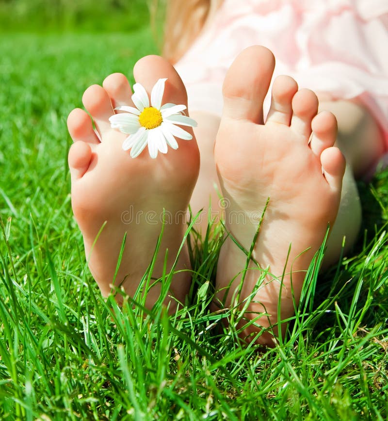 Child Feet with Daisy Flower on Green Grass in a Summer Park. Stock ...