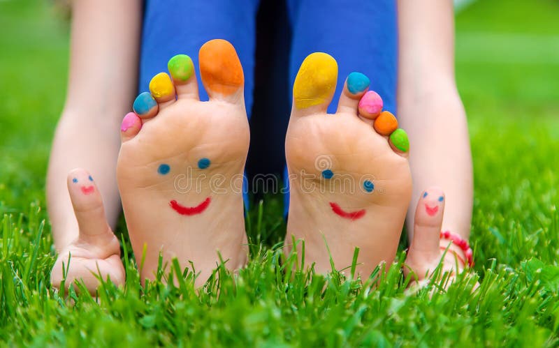 Feet of a Child on the Grass with a Painted Smile. Selection Focus ...