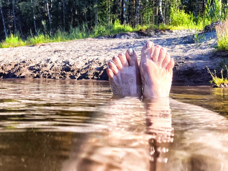 Feet Float in Clear Lake Water Under a Bright, Sunny Sky Stock Photo ...