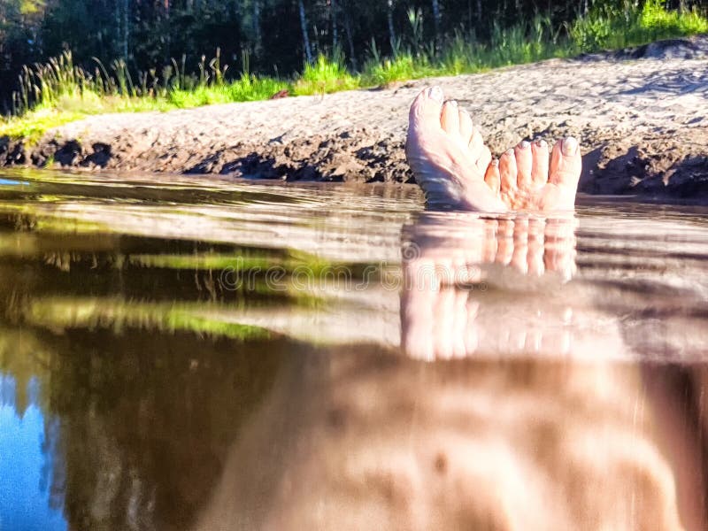 Feet Float in Clear Lake Water Under a Bright, Sunny Sky Stock Image ...