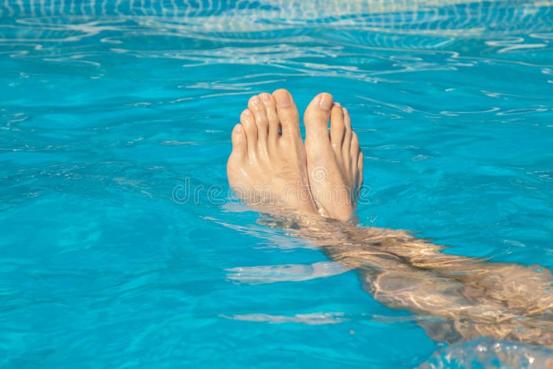 Feet floating in the pool stock image. Image of sports - 191116041