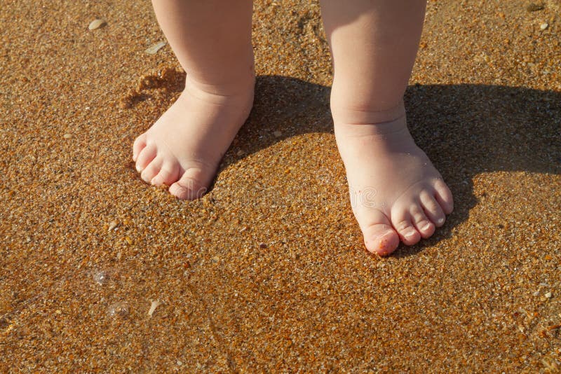 The Feet of a Small Child on the Yellow Wet Sand on the Beach Stock ...