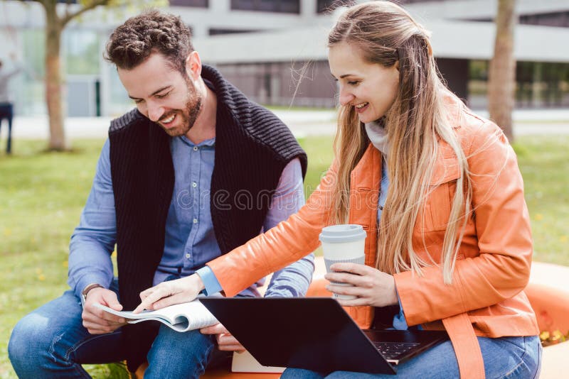 Fellow Students Looking into a Book on College Campus Stock Photo ...