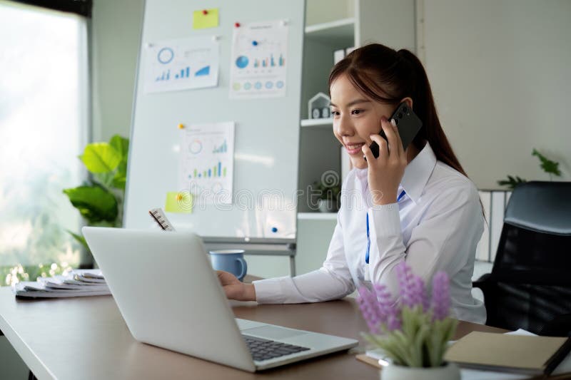Professional Female Accountant Talking on Phone while Working on Laptop ...