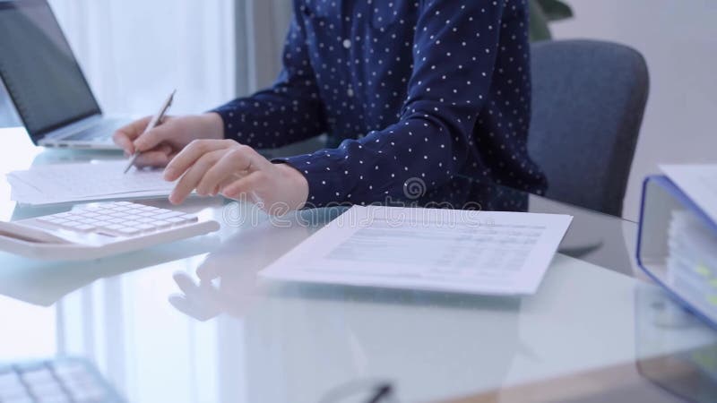 Female Accountant is Using a Laptop Computer and Calculator for ... Female Accountant is Using a Laptop Computer and Calculator for ...