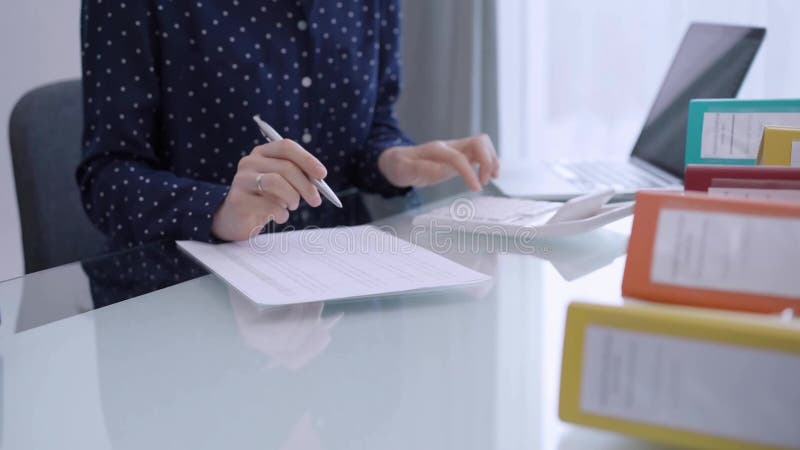 A Female Accountant is Using a Laptop Computer and Calculator To ... A Female Accountant is Using a Laptop Computer and Calculator To ...