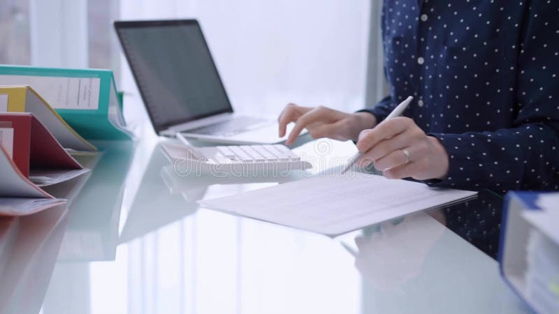 A Female Accountant is Using a Laptop Computer and Calculator To ... A Female Accountant is Using a Laptop Computer and Calculator To ...