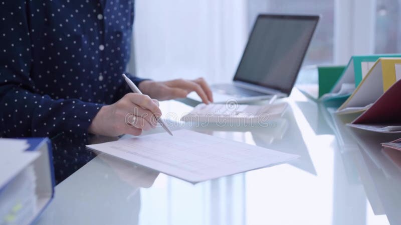 A Female Accountant is Using a Laptop Computer and Calculator To ... A Female Accountant is Using a Laptop Computer and Calculator To ...