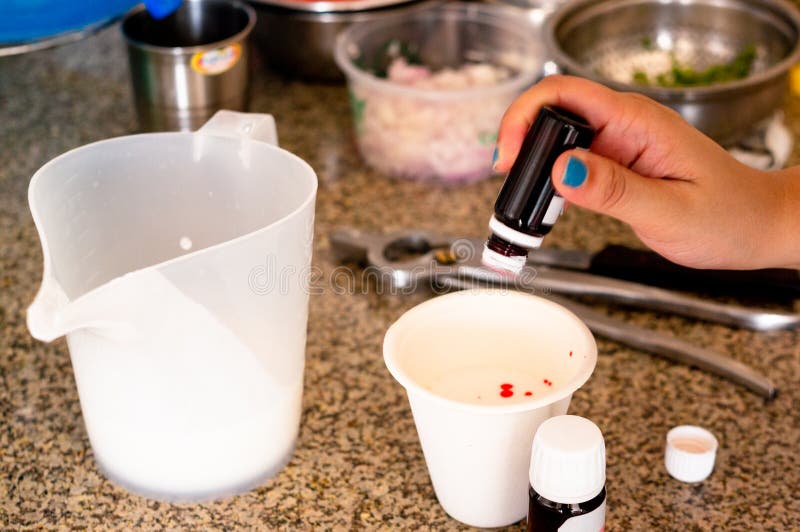 Female Adding Color Drops To Melted Soap Solution on Kitchen Counter ...