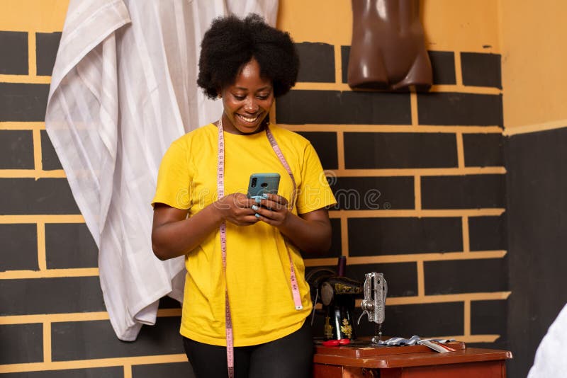 African Tailor Using Her Phone Stock Image - Image of lady, employed ...