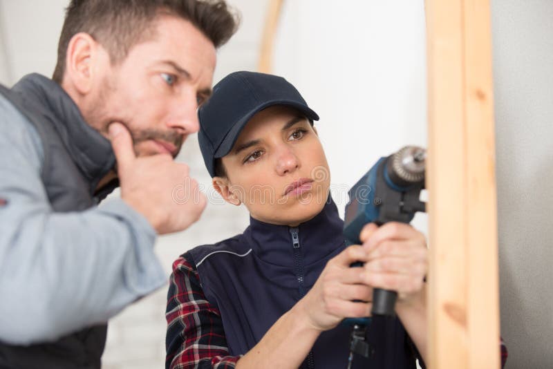 Female Apprentice Carpenter Using Drill Under Supervision Stock Image ...