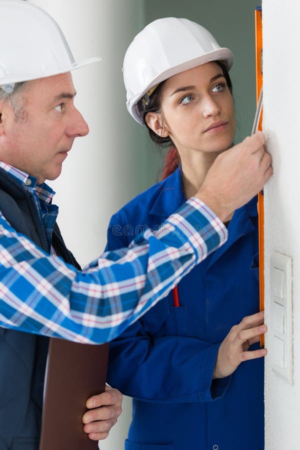Female Apprentice and Master Working on Wall Stock Photo - Image of ...