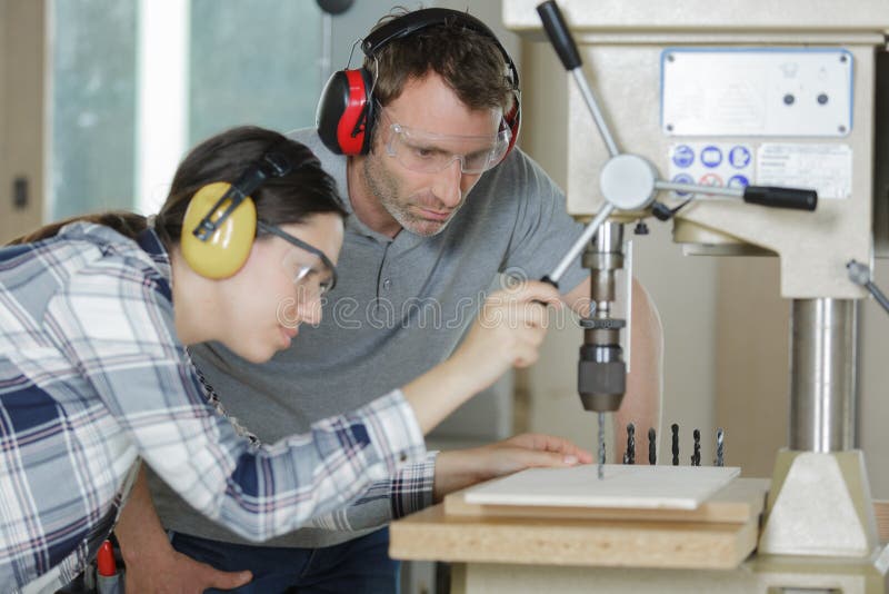 Female Apprentice Using Bench Drill Under Supervision Stock Photo ...