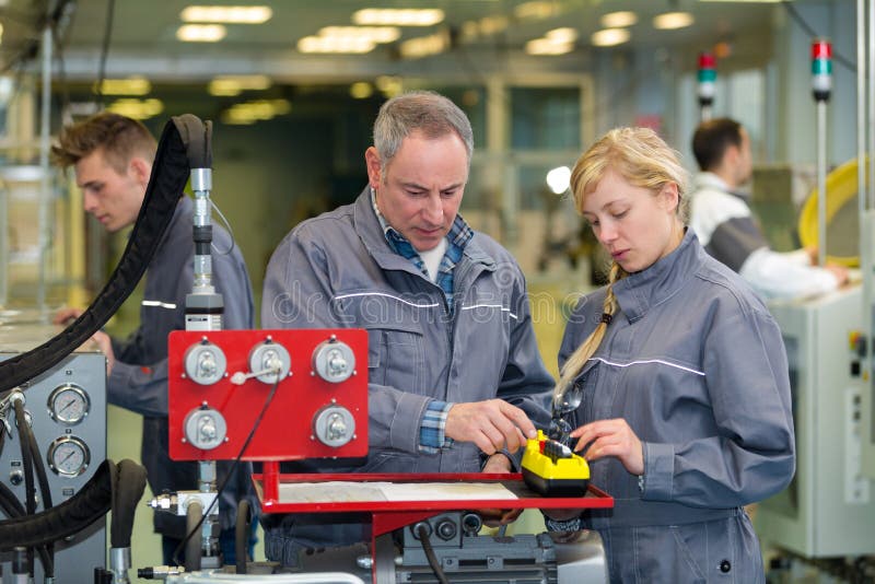 Female Apprentice and Worker Using Machine in Factory Stock Image ...