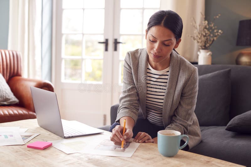 Female Architect or Interior Designer Working from Home Looking at ...