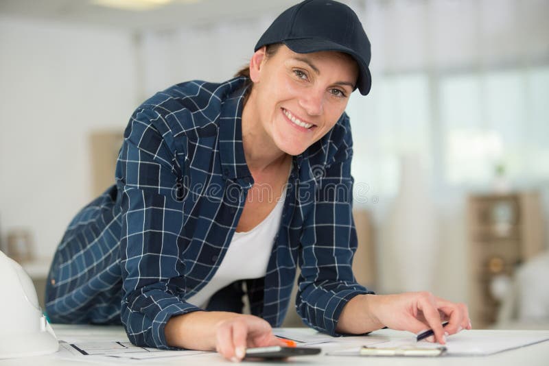 Female Architect Looking at Plans Spread Over Desk Stock Image - Image ...