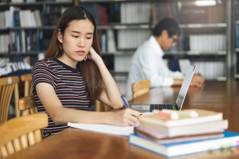 Female Asian Student Studying and Reading Book in Library Stock Photo ...