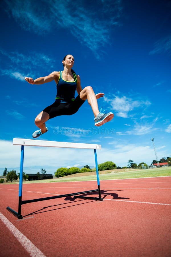 Female Athlete Jumping Above the Hurdle Stock Photo - Image of female ...