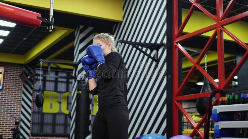 Female Athlete Practices Punches on a Simulator in the Boxing Ring ...