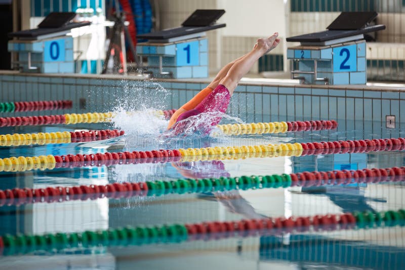 Female Athlete Preparing for a Dive Start and Jumping into the Pool ...