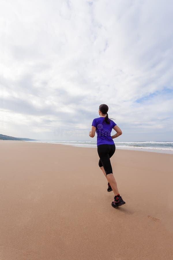 Female Athlete Running at the Beach on a Fall Day Stock Photo - Image ...