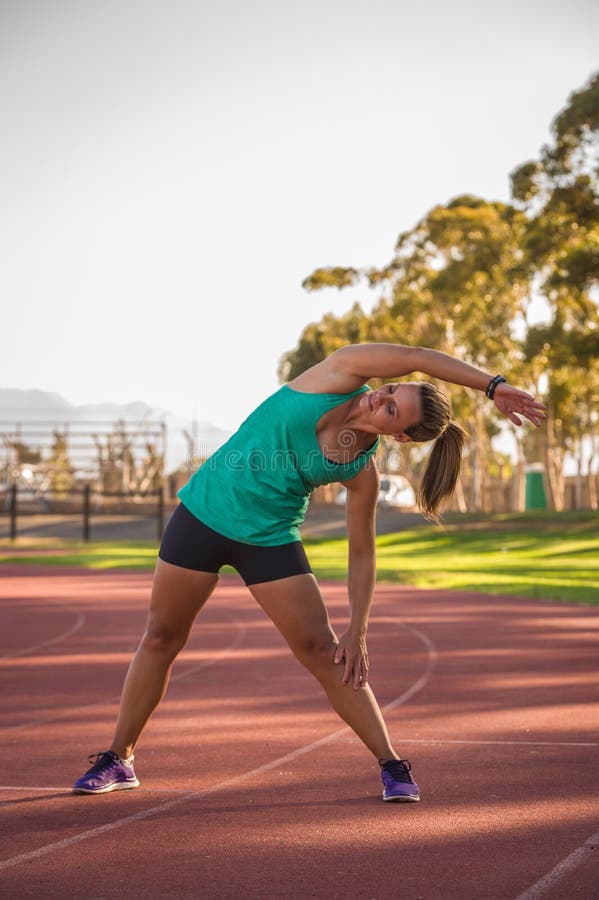 Female Athlete Stretching on a Running Track Stock Photo - Image of ...