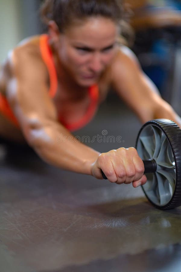Female Athlete Using Abs Roller Wheel, Engaging Core Muscles for ...