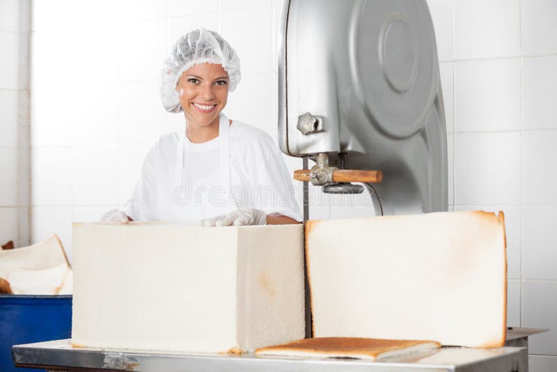 Female Baker with Bread Loaf Standing at Cutting Machine Stock Image ...