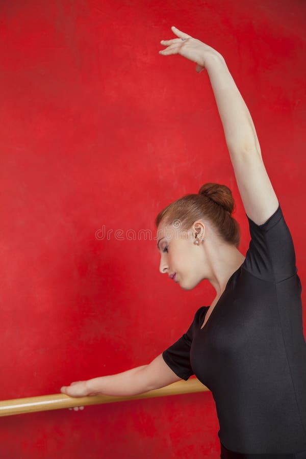Female Ballet Dancer with Hand Raised at Barre Stock Image - Image of ...