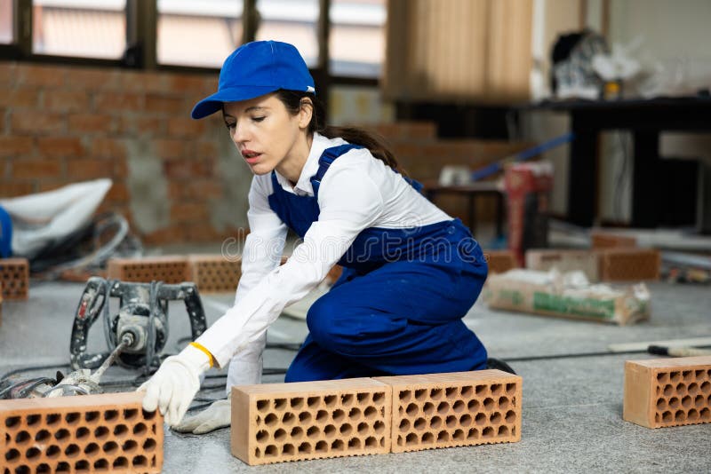 Female Builder Arranging Bricks Inside Building Under Construction ...