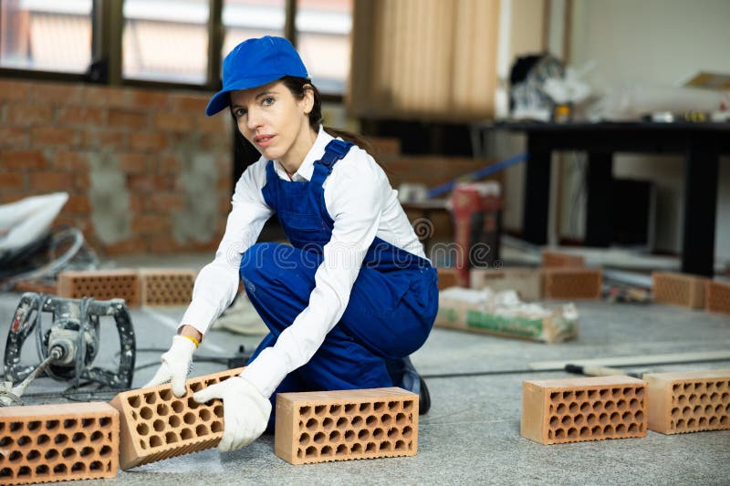Female Builder Arranging Bricks Inside Building Under Construction ...